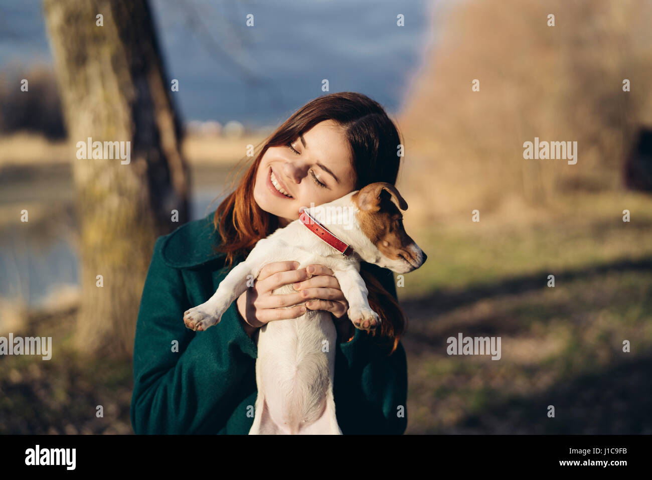 Caucasian woman lifting an hugging dog Stock Photo - Alamy