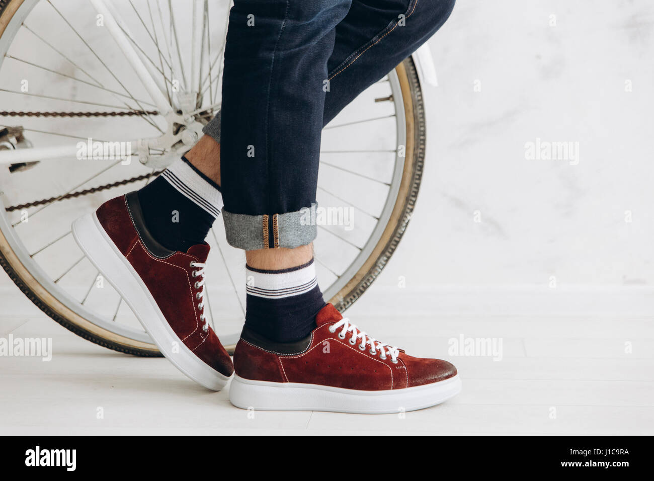 Legs of man standing near bicycle wheel Stock Photo - Alamy