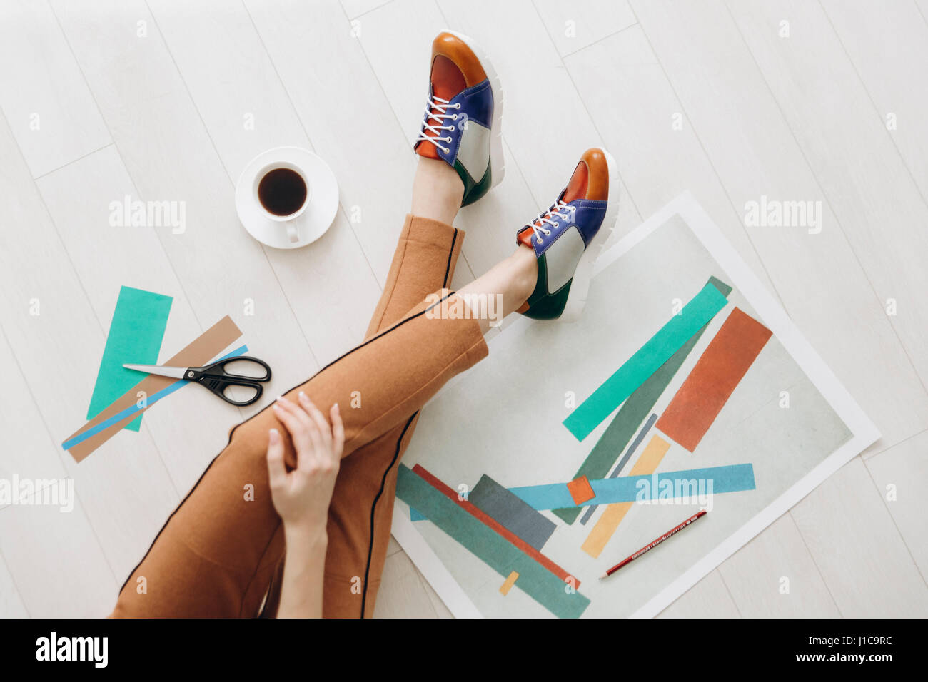 Legs of woman designer sitting on floor wearing multicolor shoes Stock ...
