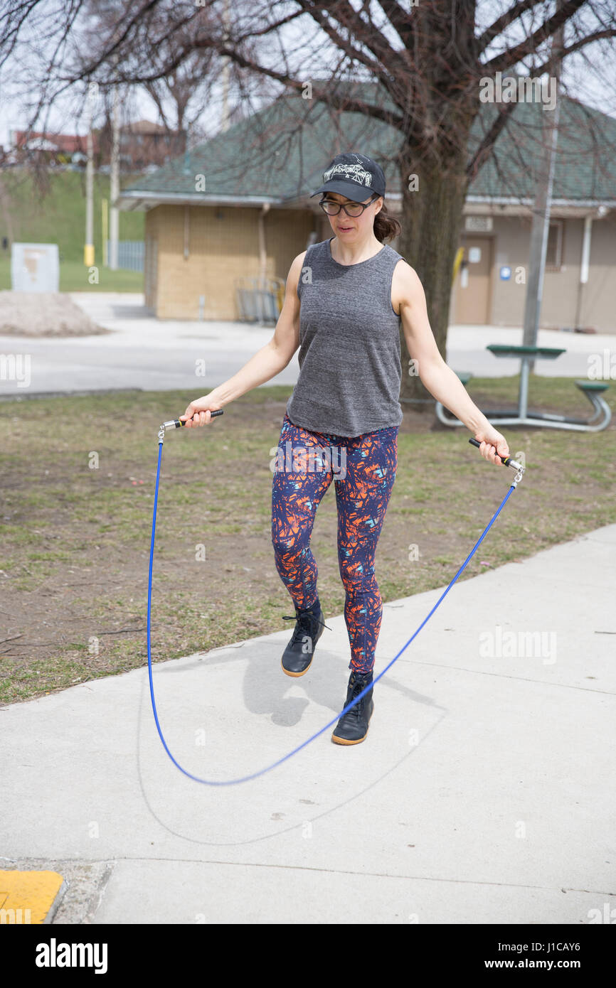 WOMAN SKIPPING ROPE IN PARK Stock Photo - Alamy
