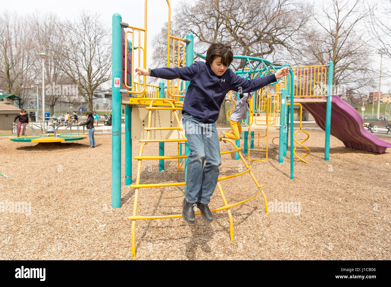 TEN YEAR OLD BOY JUMPS OFF PLAY STRUCTURE ON WARM SPRING DAY AT ...