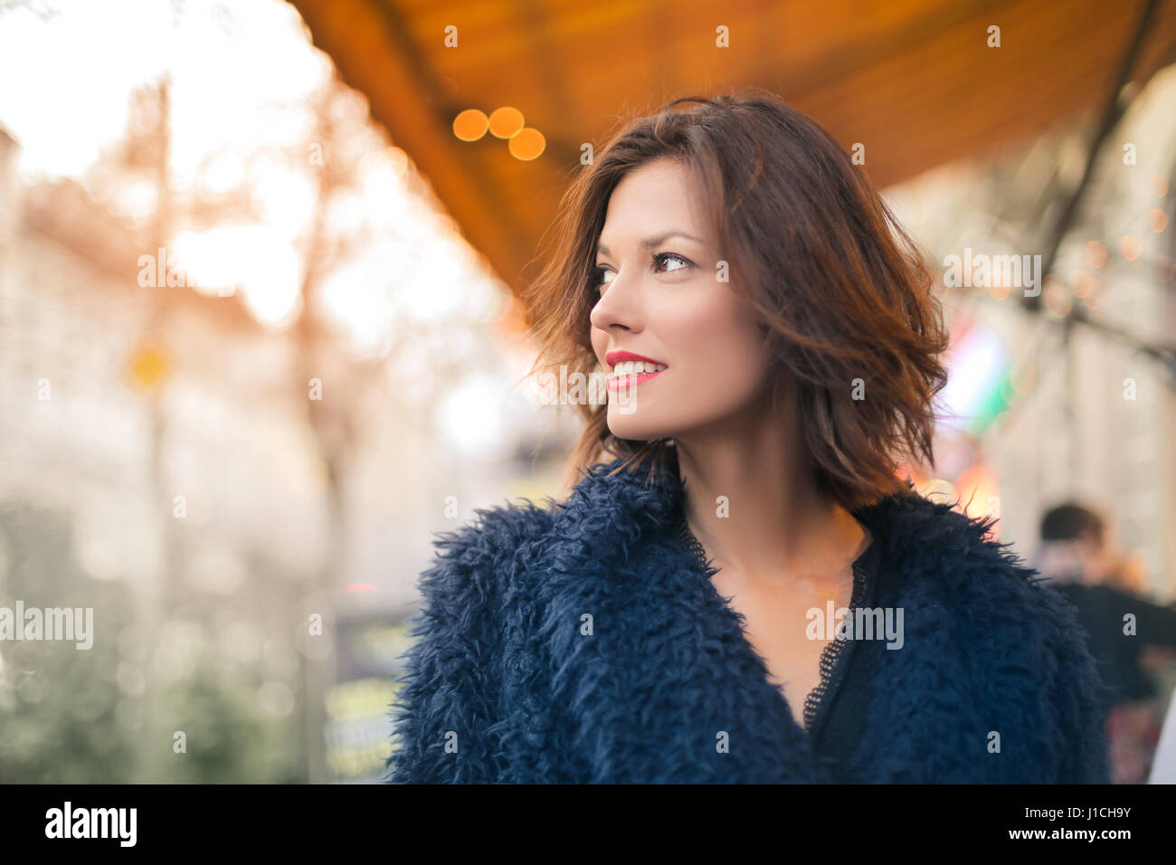 Woman walking in the street and looking around Stock Photo - Alamy