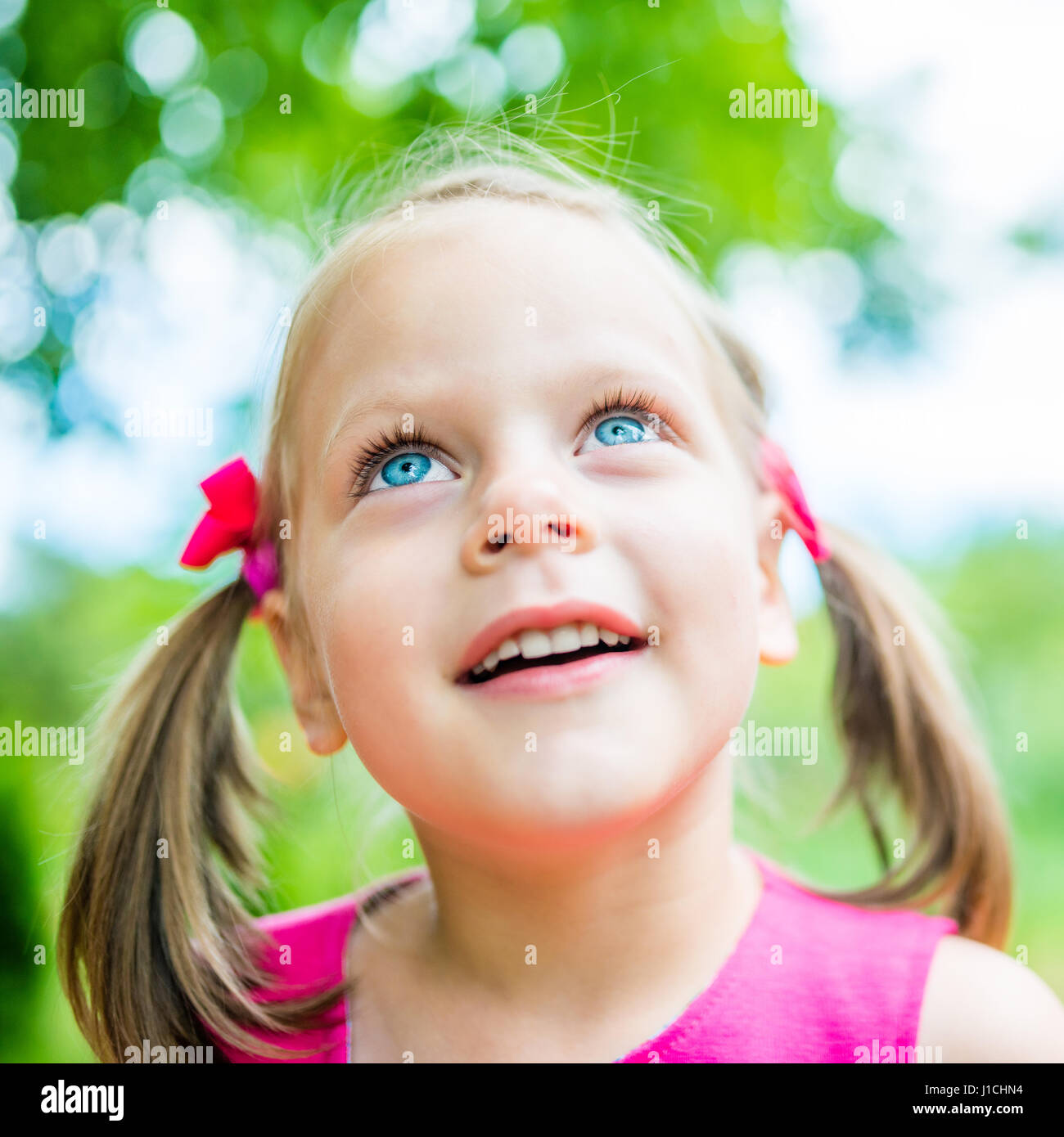 Summer portrait of happy cute laughing child girl - looking up ...