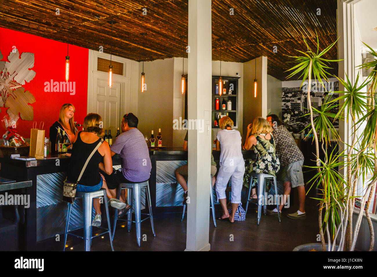 People enjoying a wine tasting at the colorful and modern tasting room ...