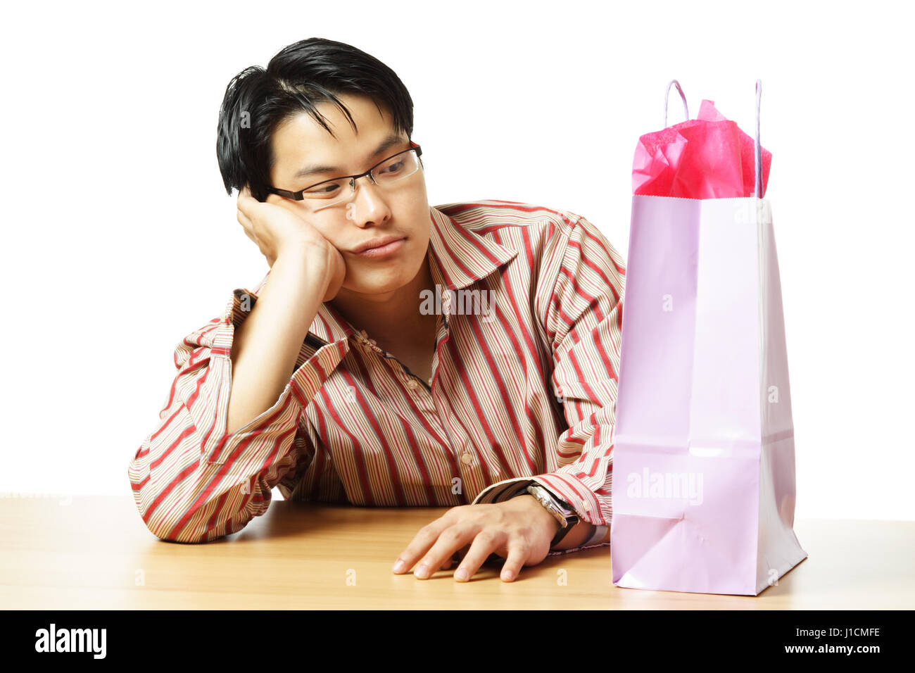 An isolated shot of a sad young man with a shopping bag Stock Photo - Alamy