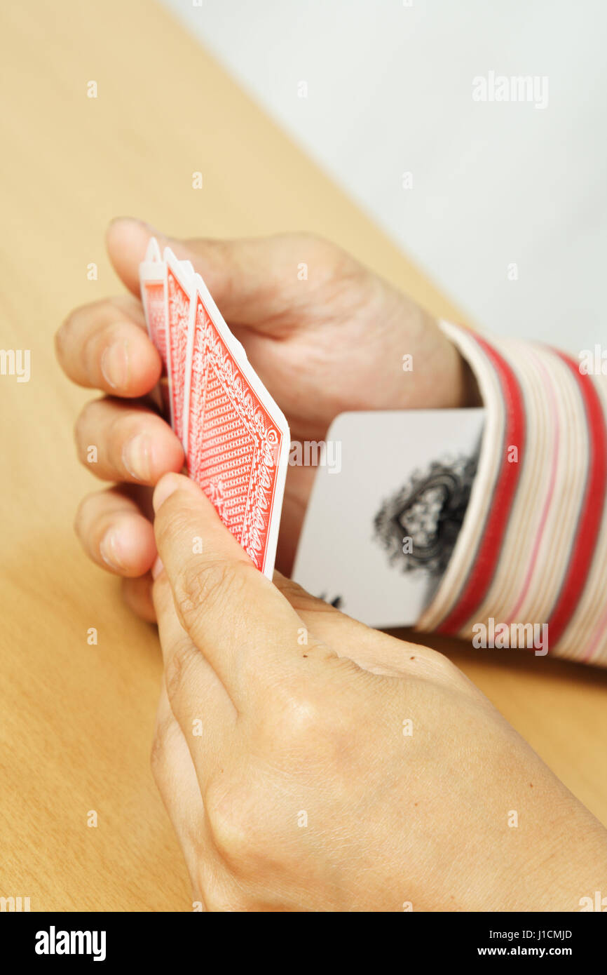 A shot of a man cheating while playing cards Stock Photo - Alamy
