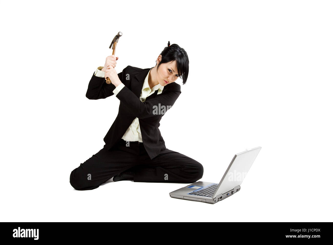 An angry and stressed businesswoman is about to smash a laptop with a ...