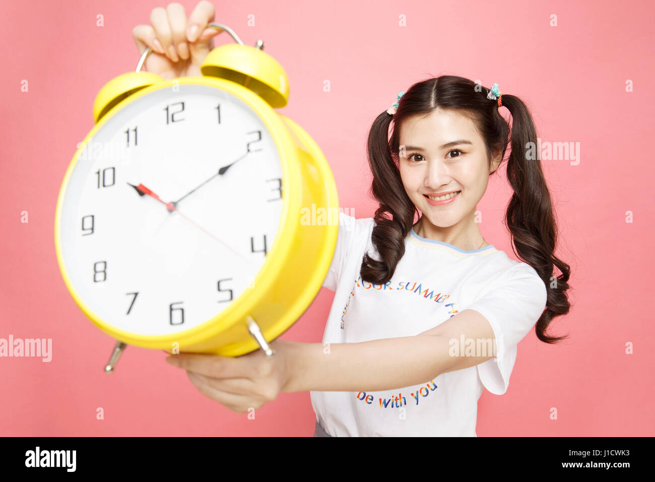 A young girl with a clock Stock Photo - Alamy