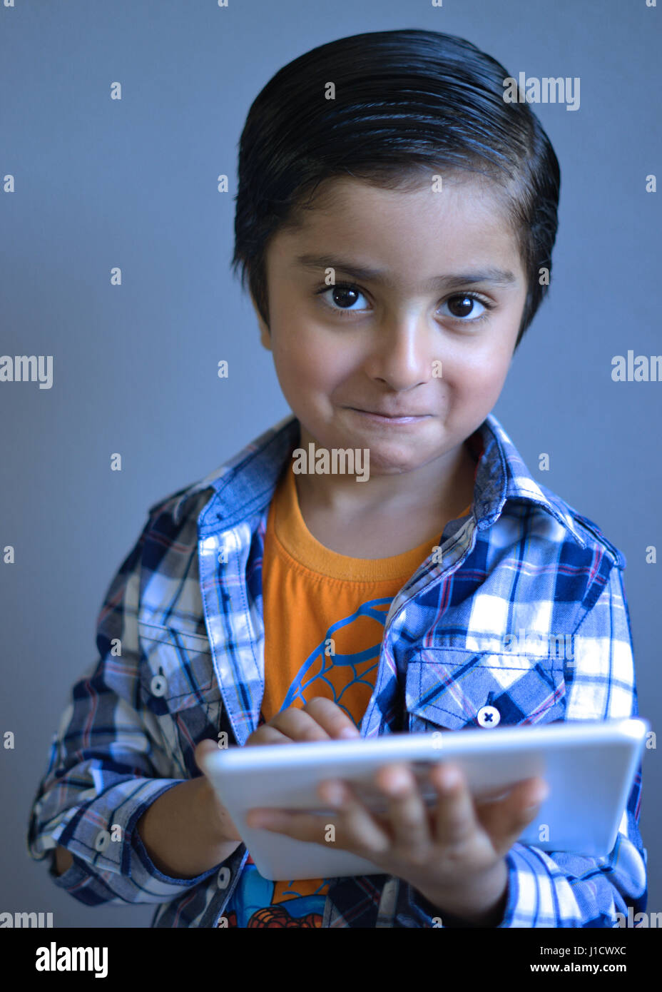 Kid with tablet computer. Smiling child with digital technology looking ...