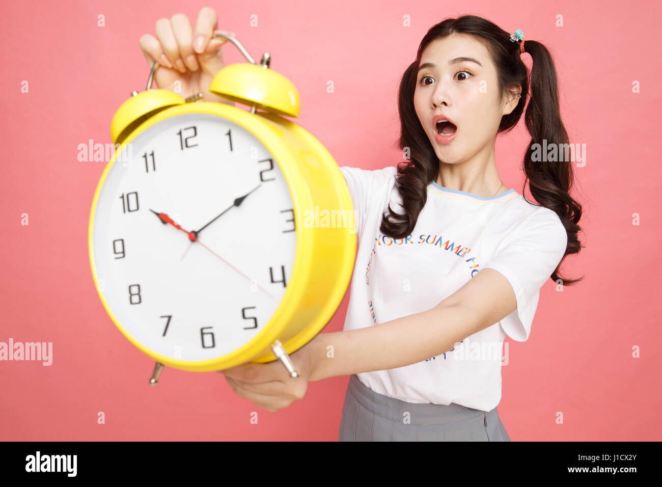 A young girl with a clock Stock Photo - Alamy