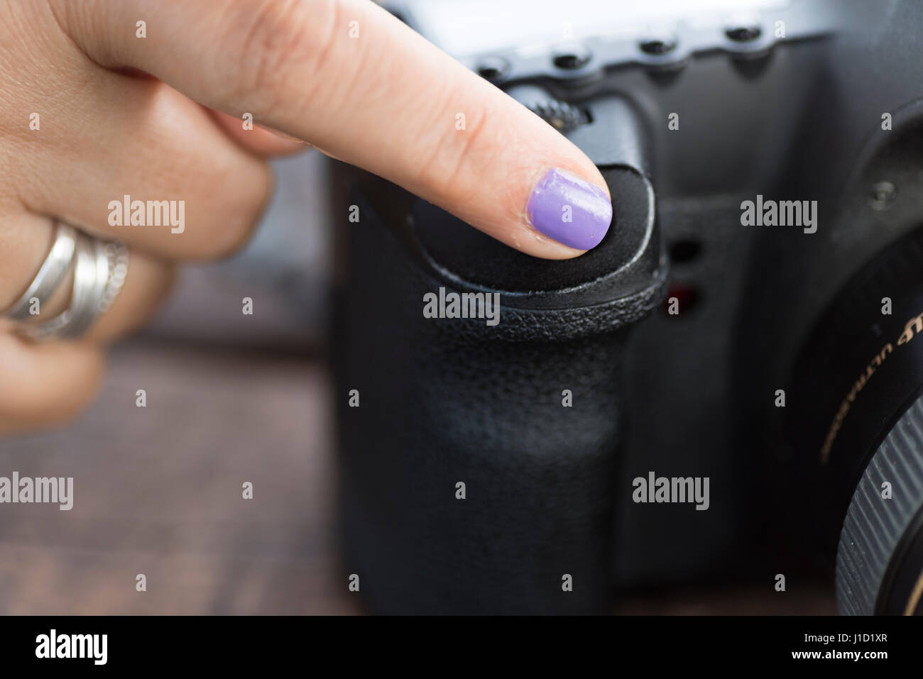 a female finger pushing the release button of a professional digital ...
