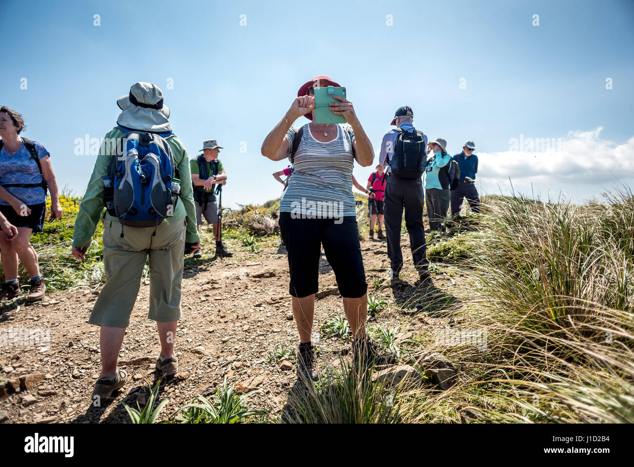 Tourists stop to take photographs on the Cami de Cavalls coastal path ...