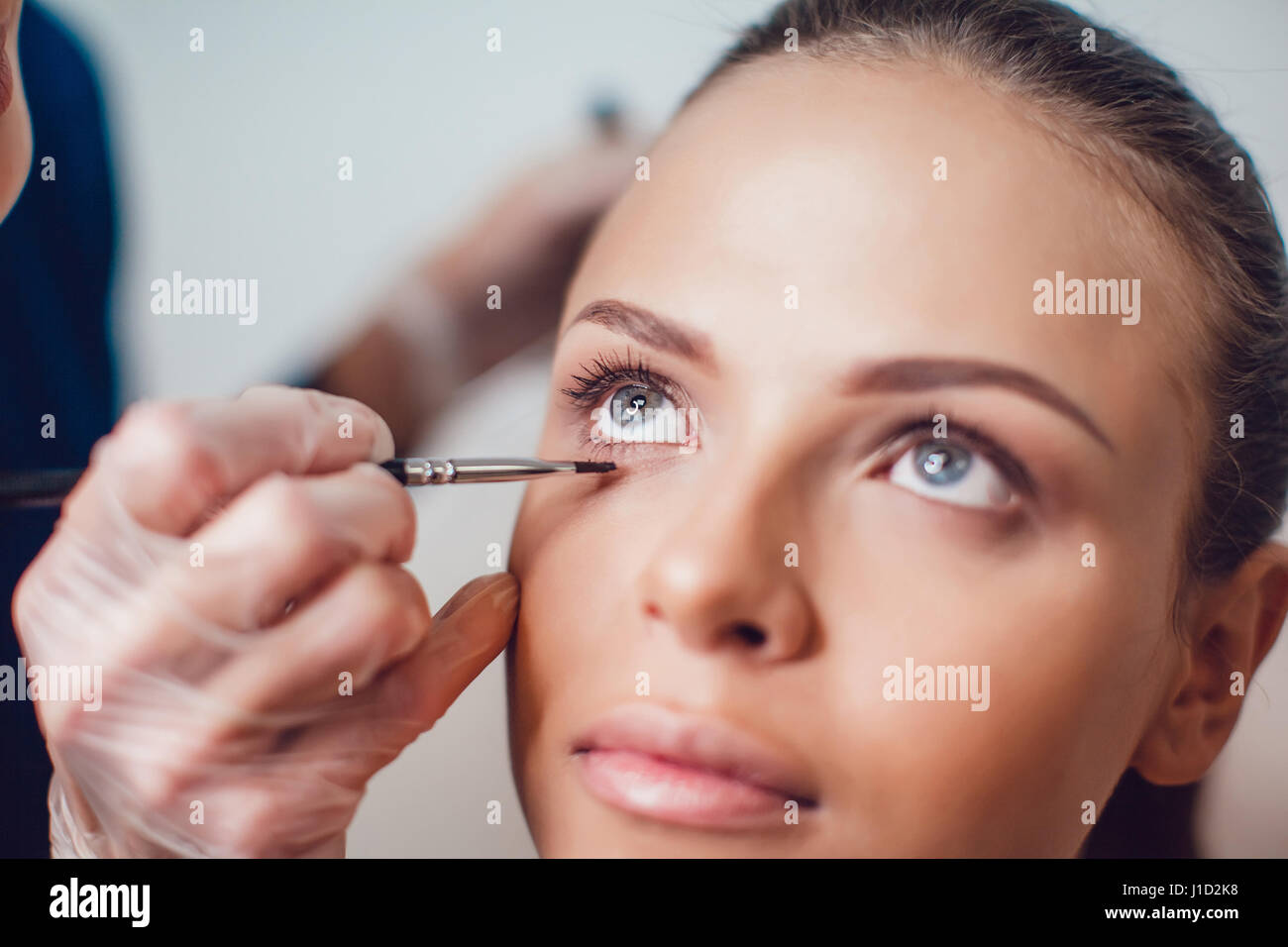 Professional make-up artist makes eye makeup of model. Beauty and ...