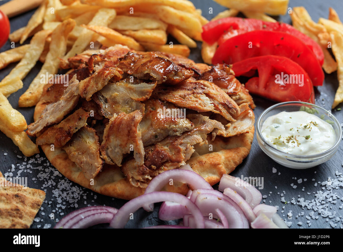 Greek gyros dish on a black plate Stock Photo - Alamy