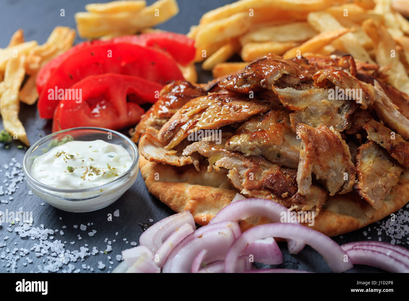 Greek gyros dish on a black plate Stock Photo - Alamy