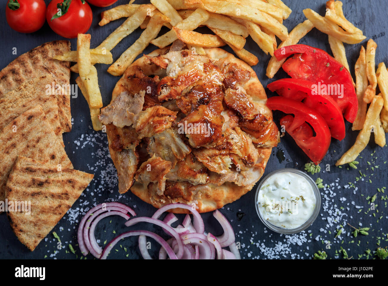 Greek gyros dish on a black plate - top view Stock Photo - Alamy