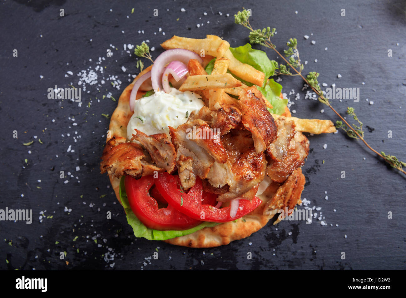 Greek gyros dish on a black plate - top view Stock Photo - Alamy