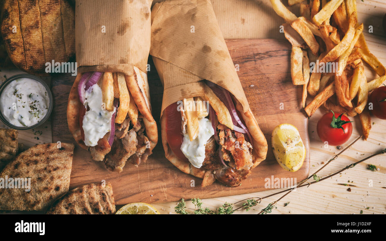 Greek gyros wrapped in pita breads on a wooden background - top view ...