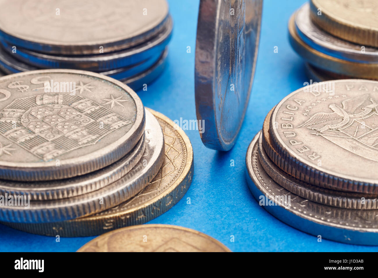 Different kinds of coins over a blue background. Macro detail ...