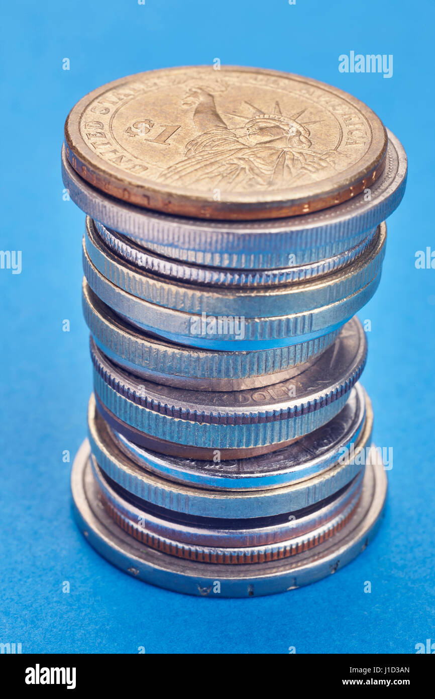 Different kinds of coins over a blue background. Macro detail. Vertical ...