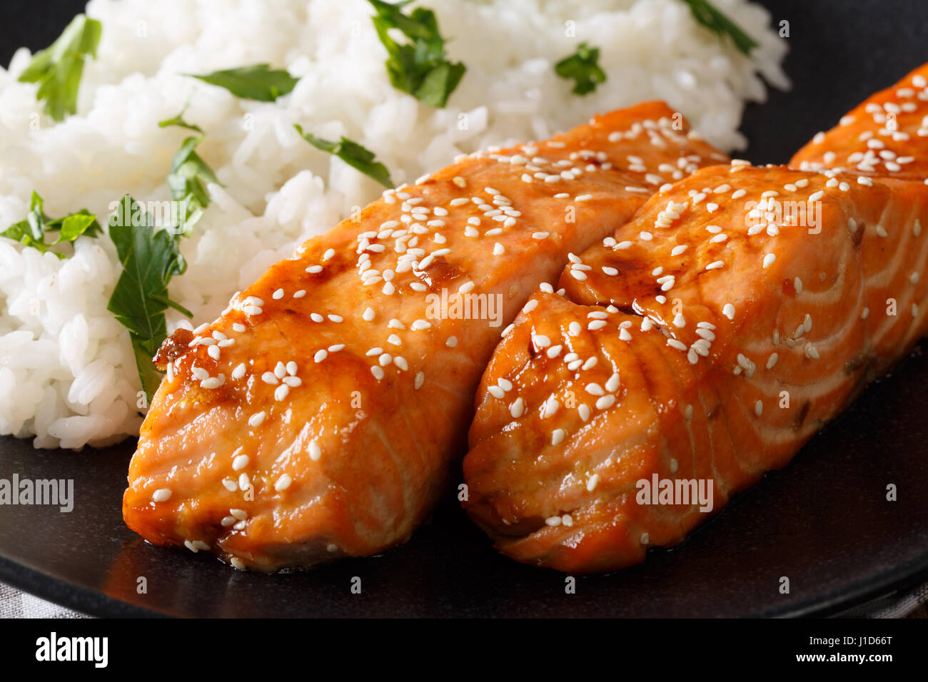 Fillet of salmon with honey, sesame and rice garnish close-up on a ...