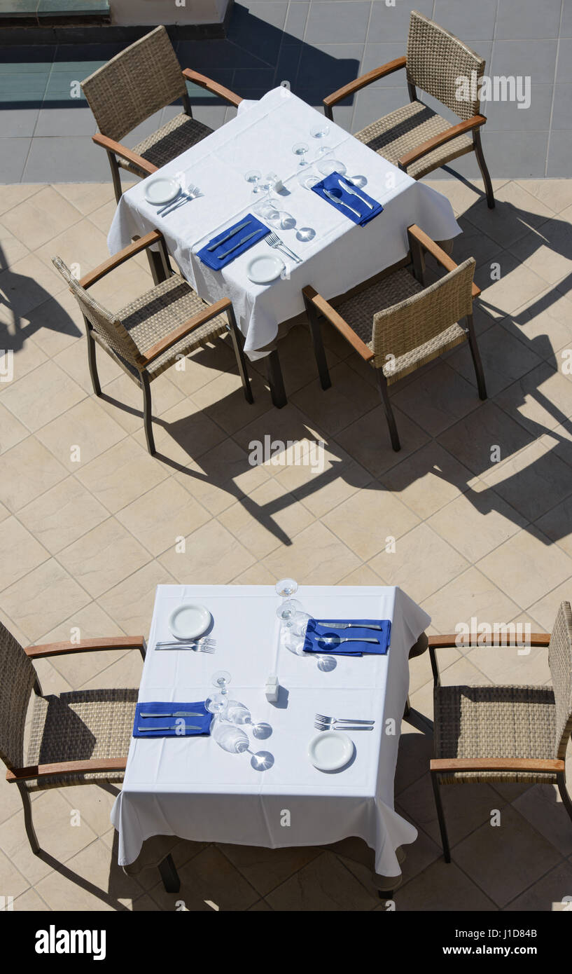 High angle view of tables with initial setting and chairs are on tiled ...