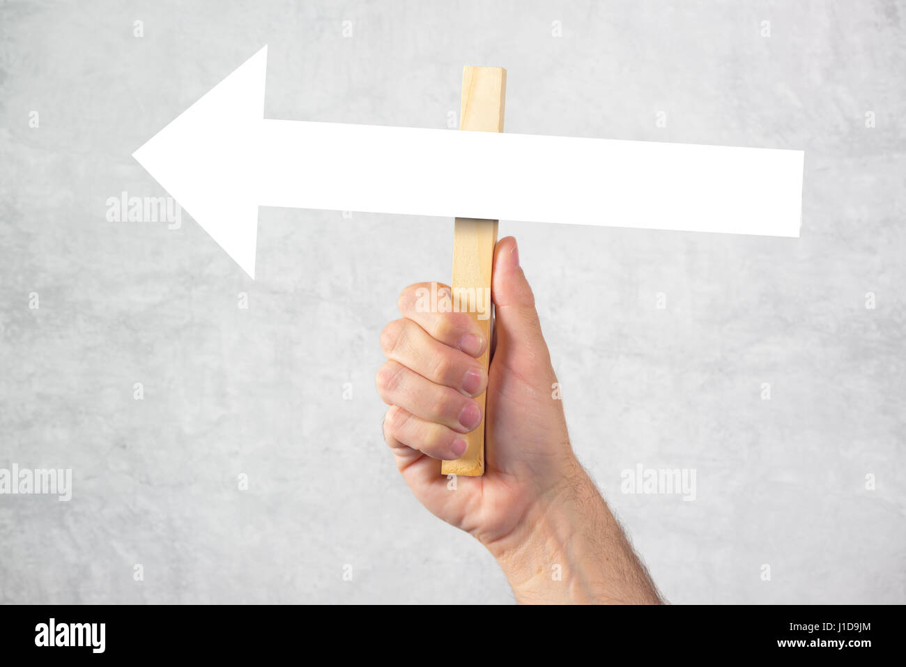 Man holding guiding direction arrow sign in hand, concept of guidance ...