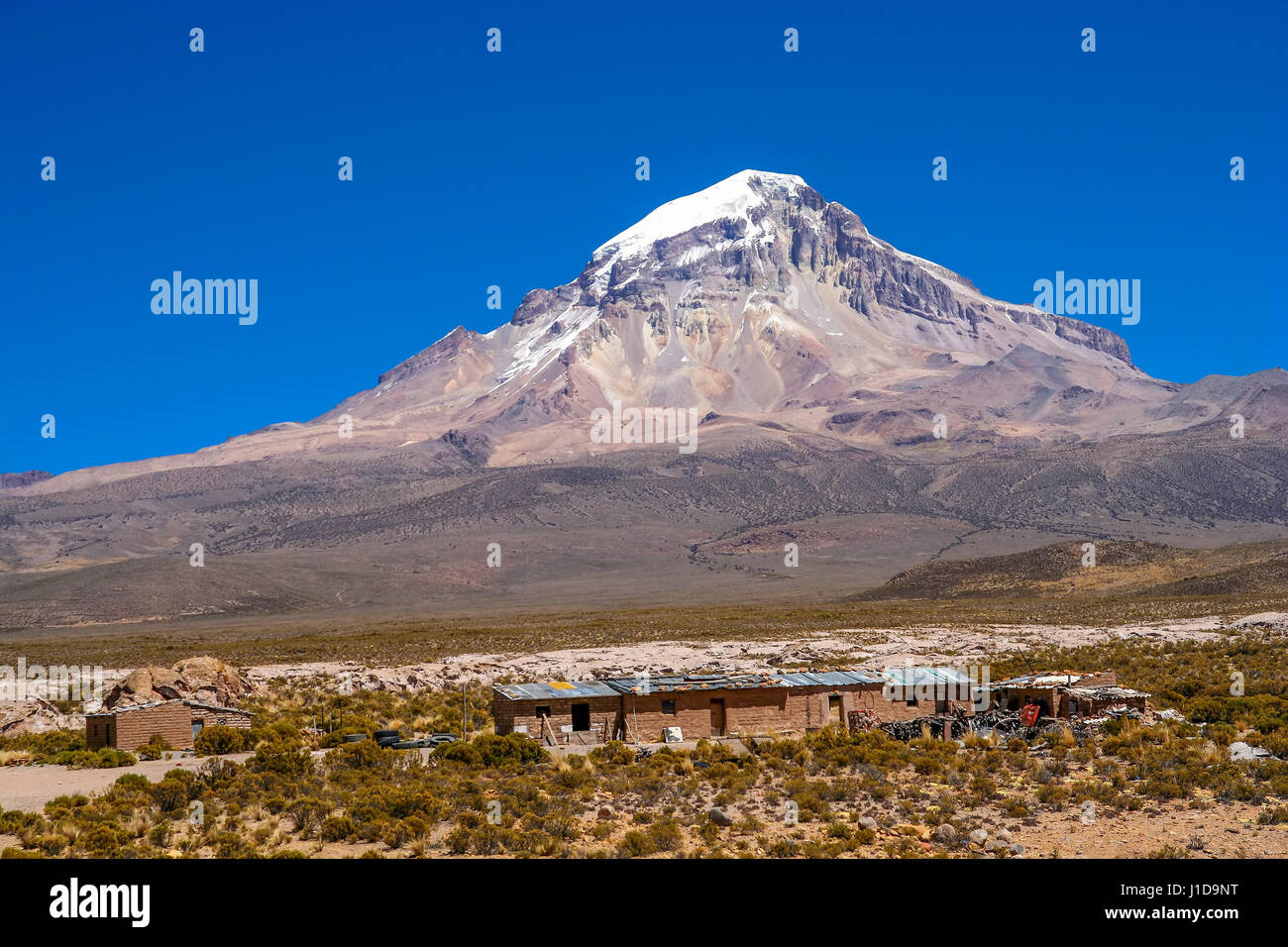 Primitive huts at the foot of the beautiful Nevado Sajama volcano in ...