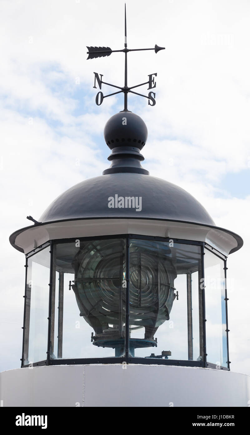 Classical Scandinavian white lighthouse tower, upper part with lamp and ...