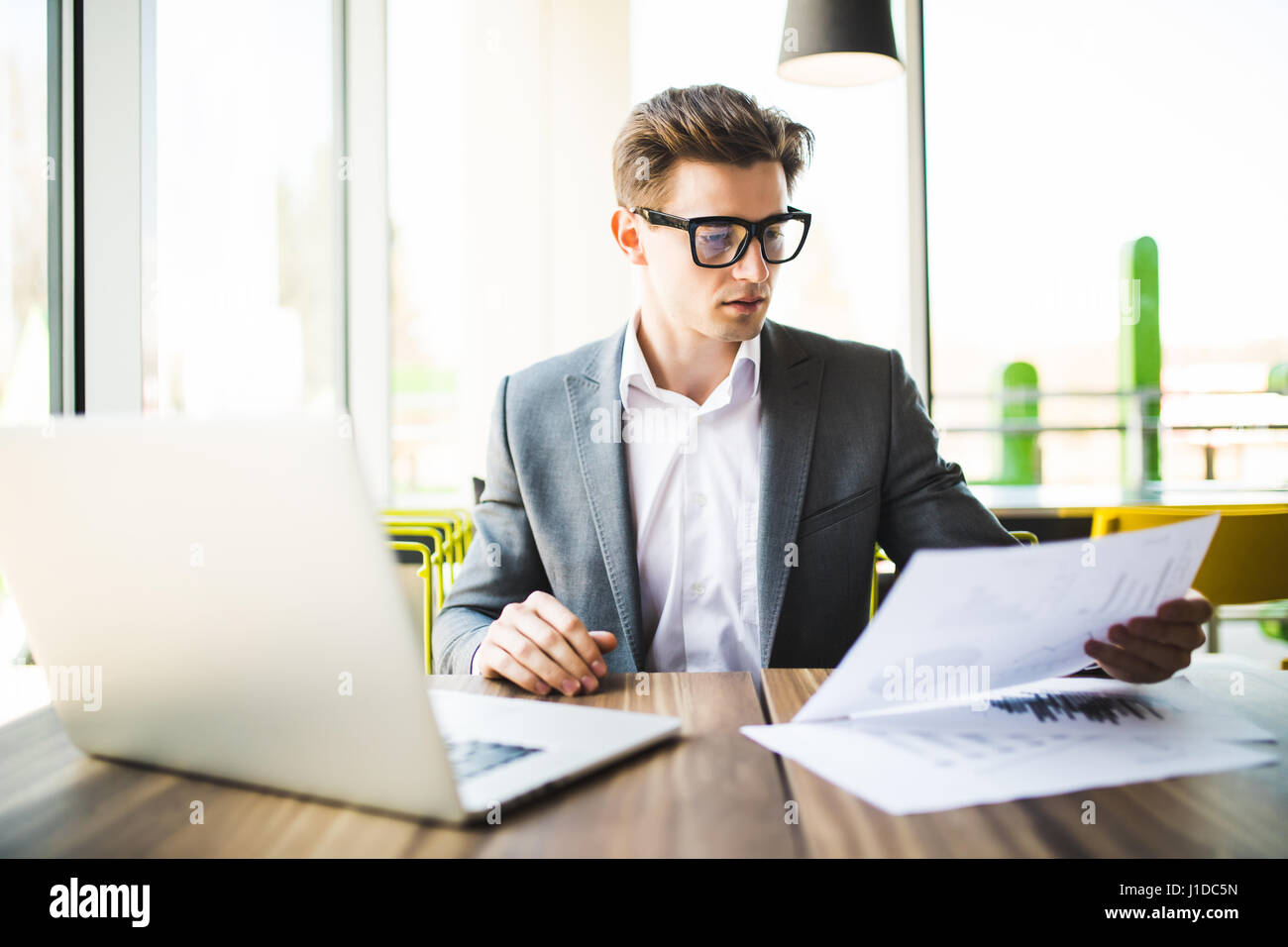 Business man working at office with laptop, tablet and graph data ...