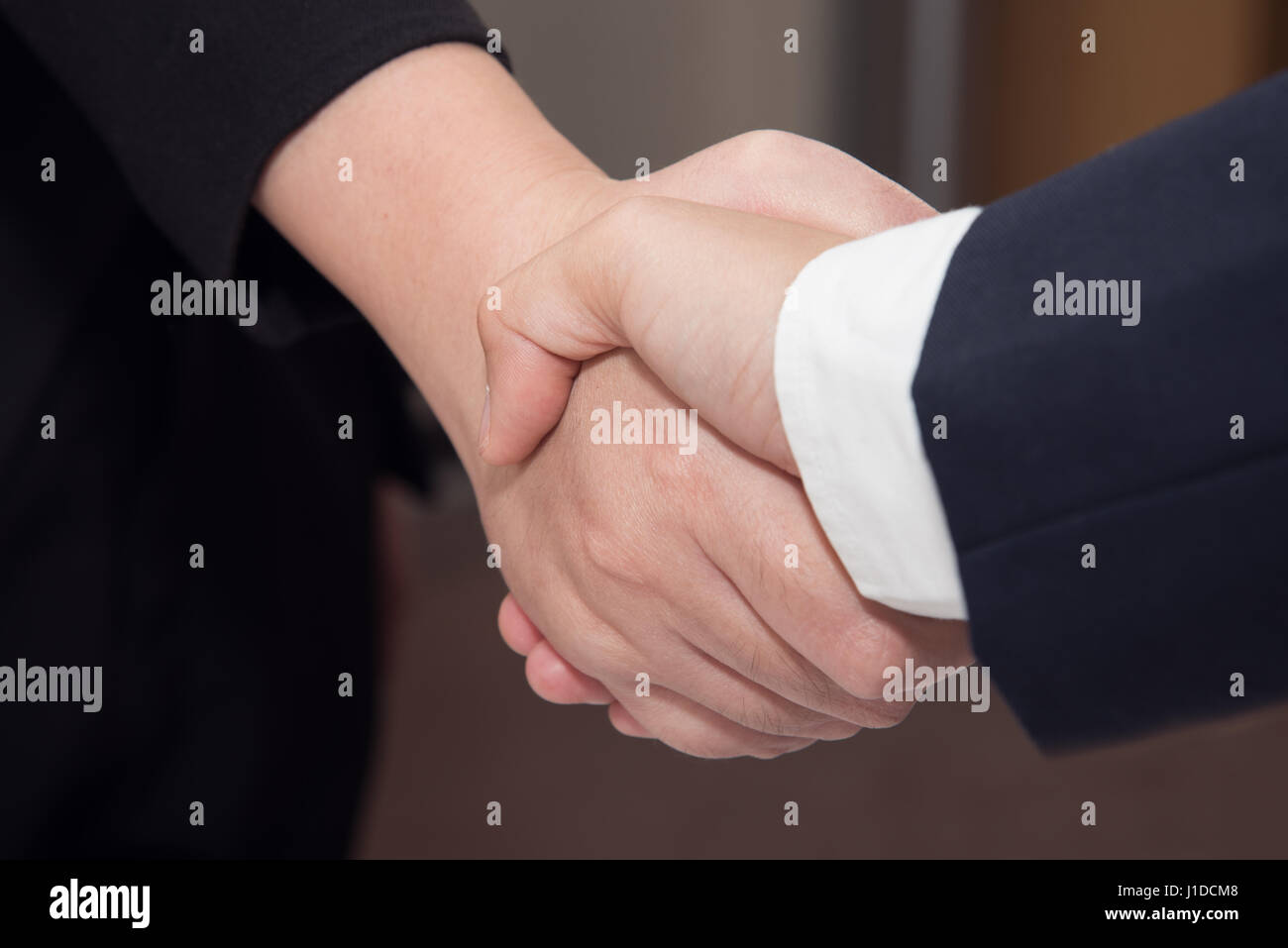 Two confident Businessman and businesswoman shaking hands over a deal ...