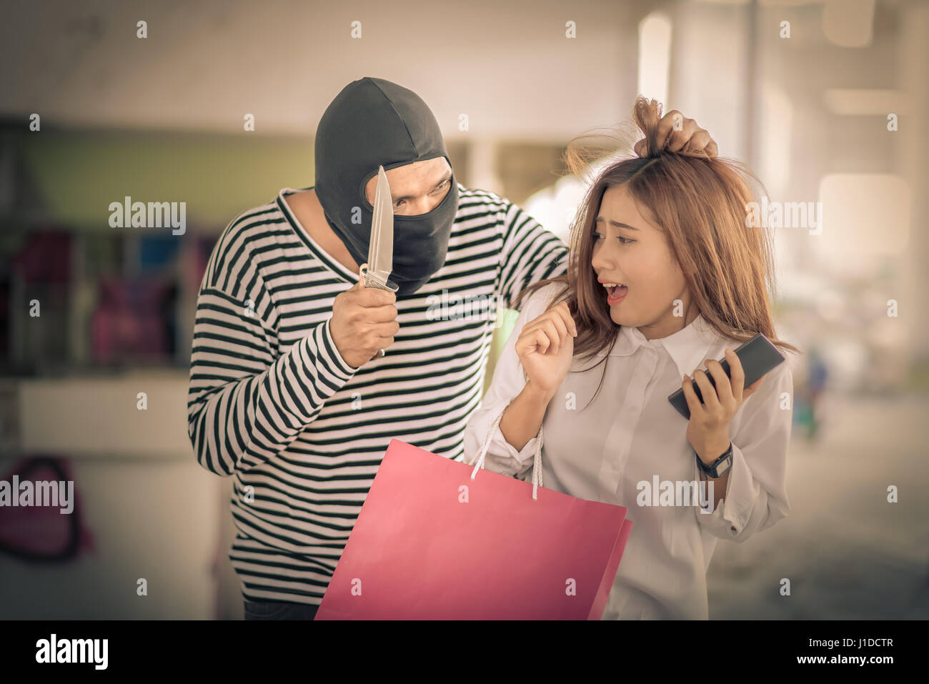 Thief stealing young woman shopping bag and threatening with knife ...