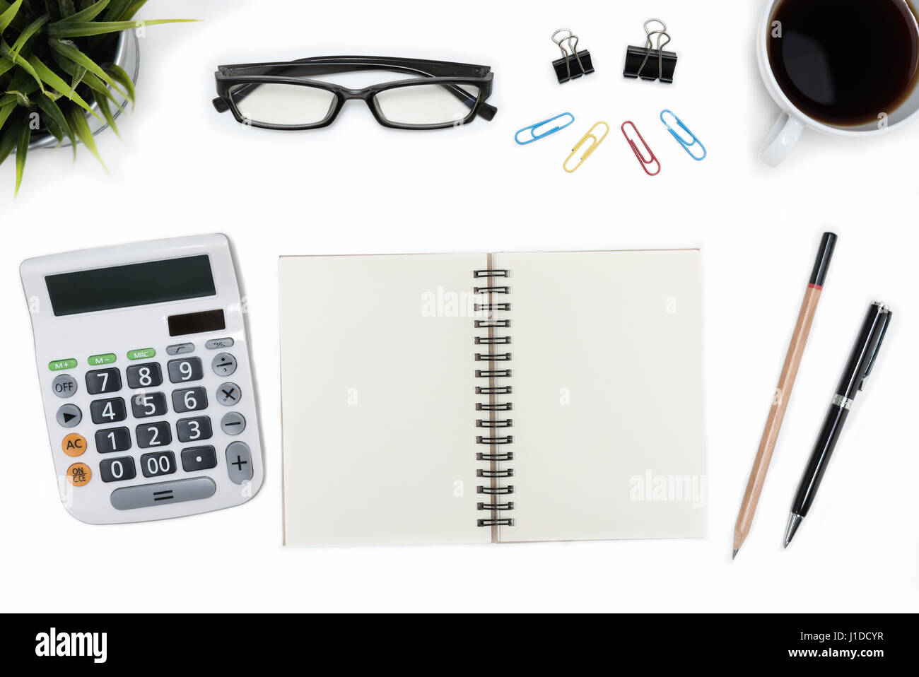 Open spiral blank notebook with calculator, pen, pencil, eye glasses ...