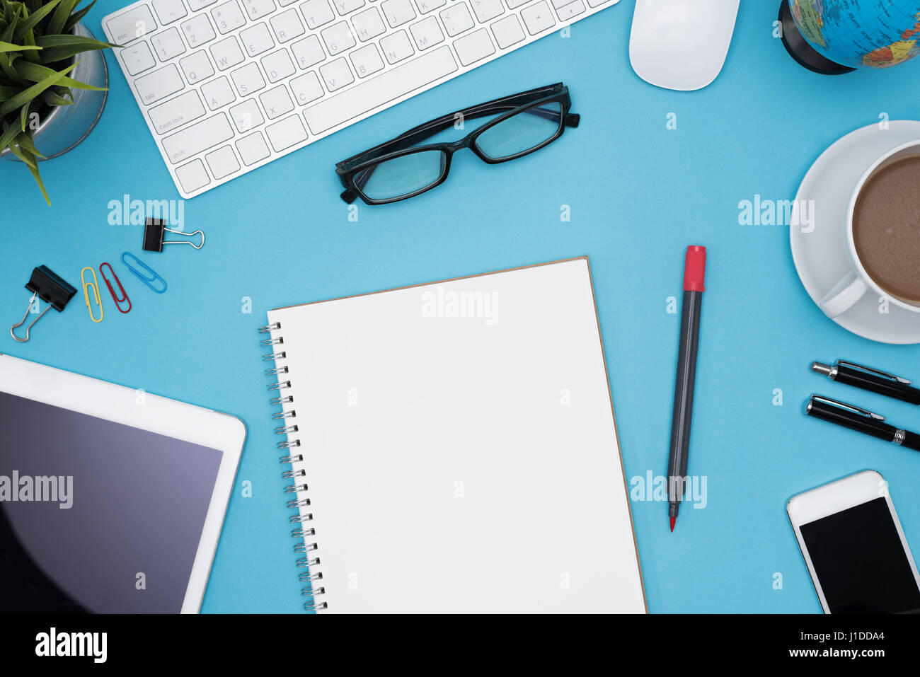 Modern blue office desk table with computer, tablet, cellphone, other ...