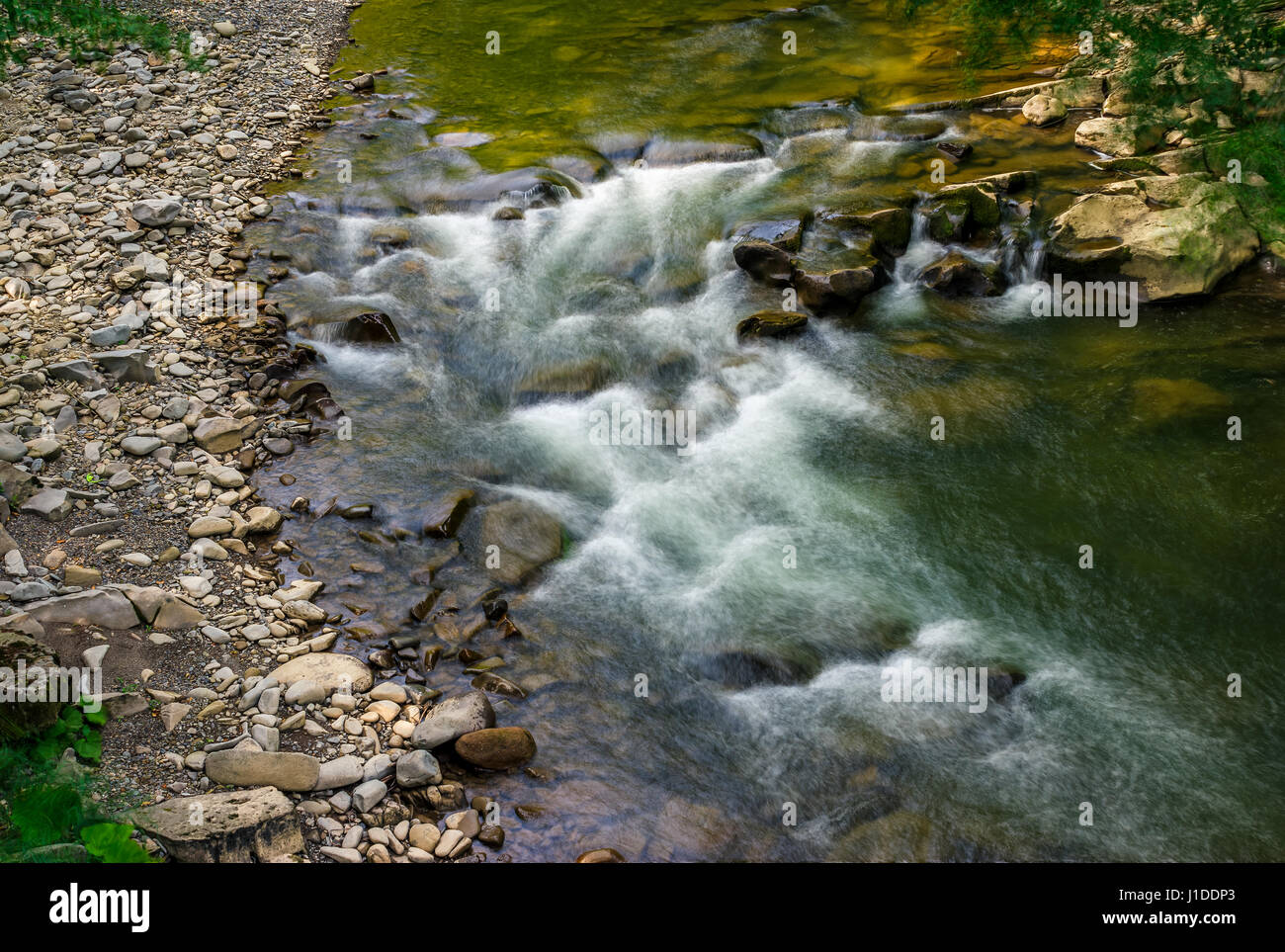 Rapid stream flow along shore covered with stone. beautiful nature view ...