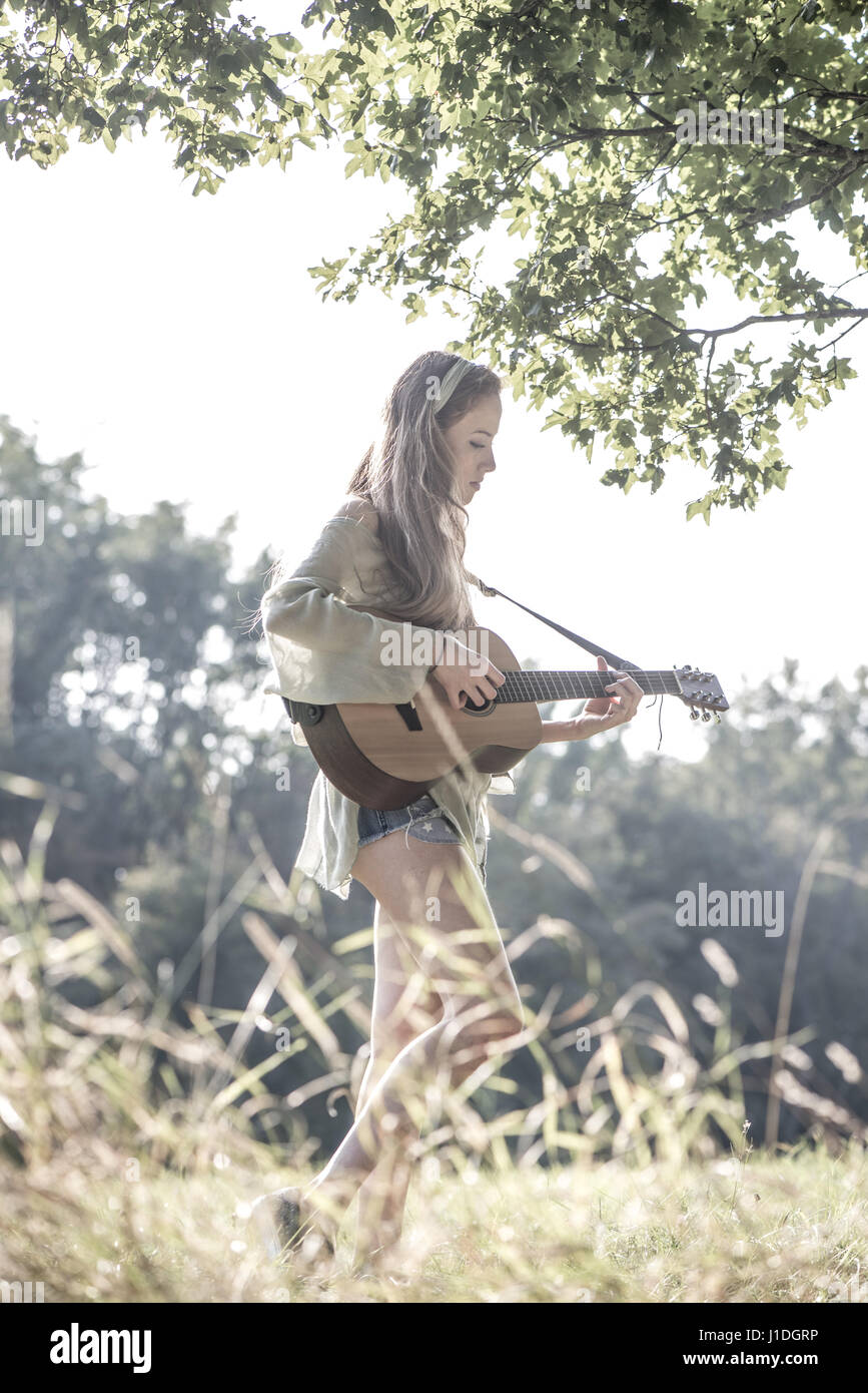 Young singer song-writer musician guitar girl in autumn forest, Vienna ...