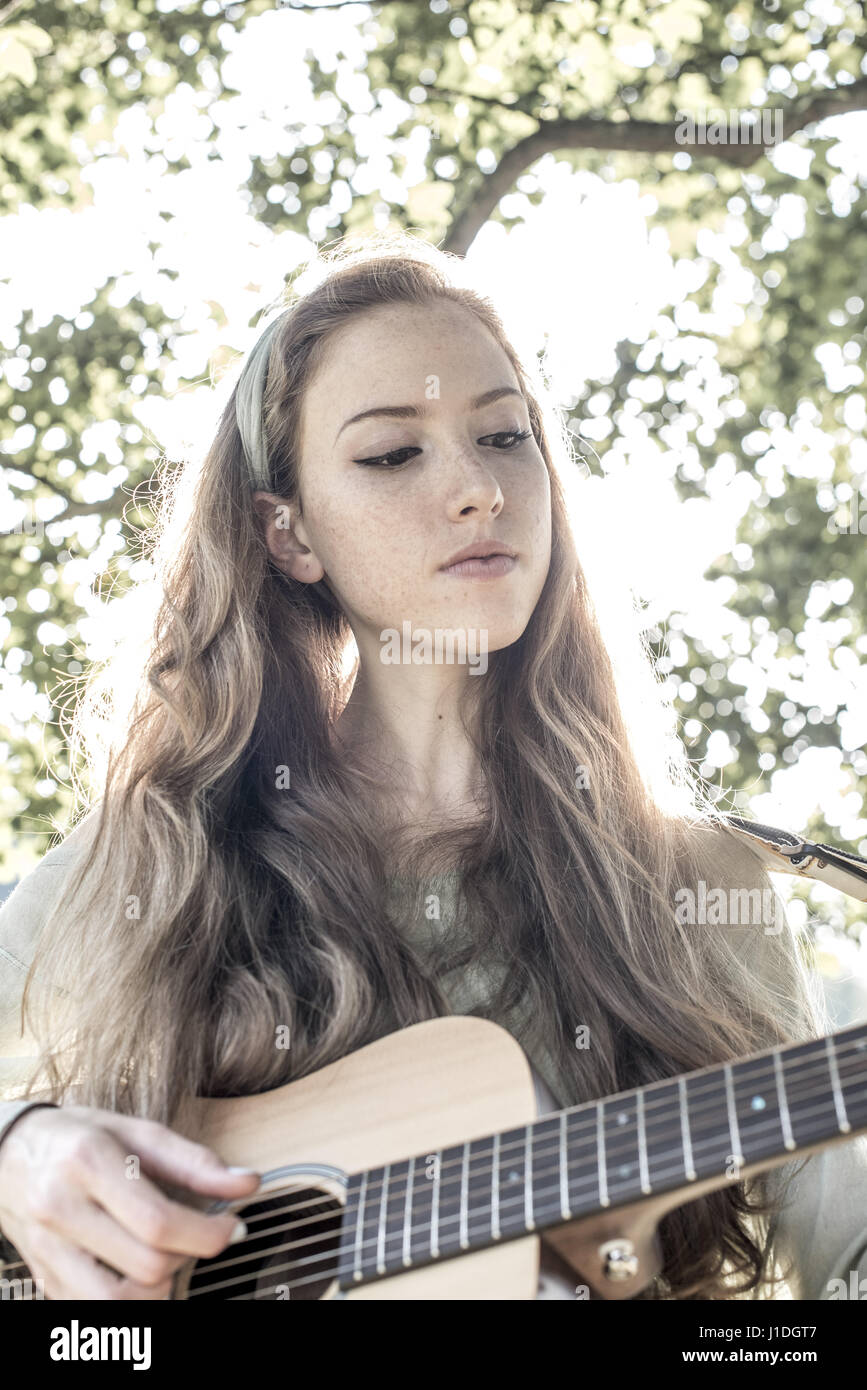 Young singer song-writer musician guitar girl in autumn forest, Vienna ...