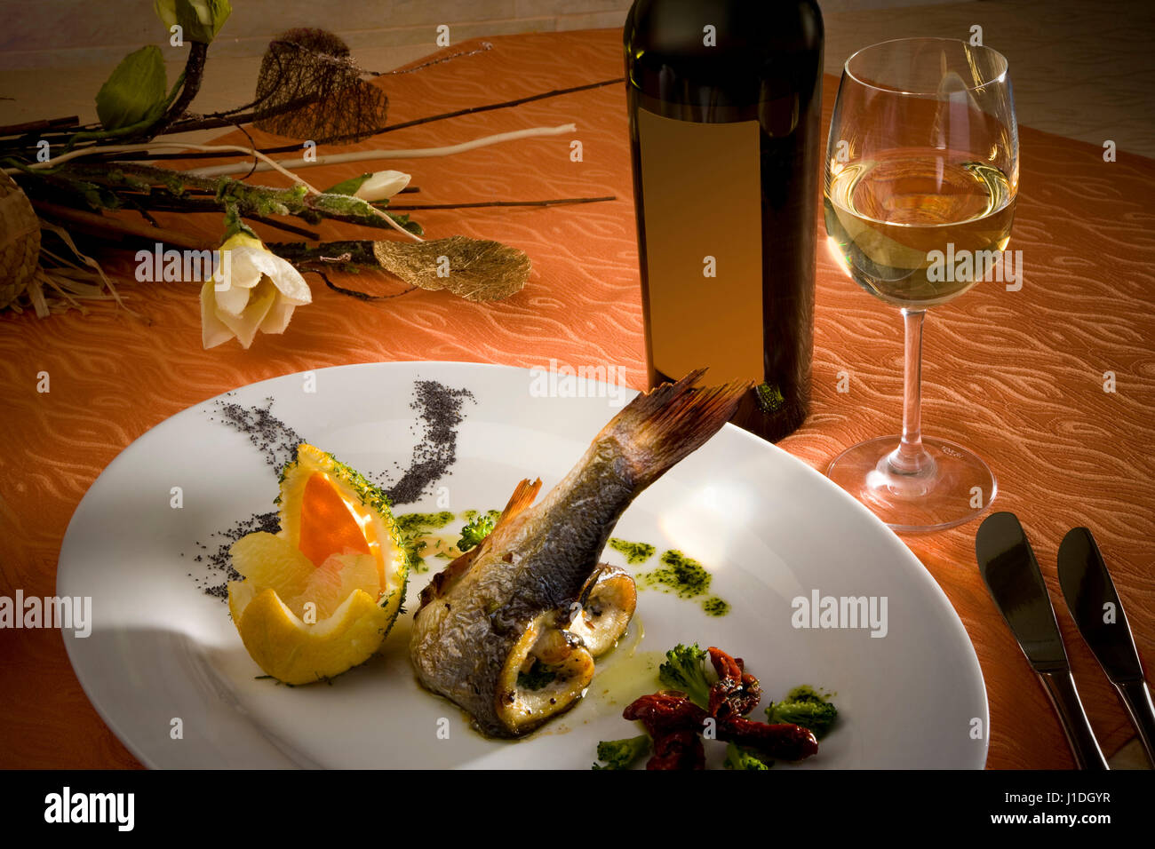 Refined gourmet fish dinner with a glass and a bottle of white wine ...