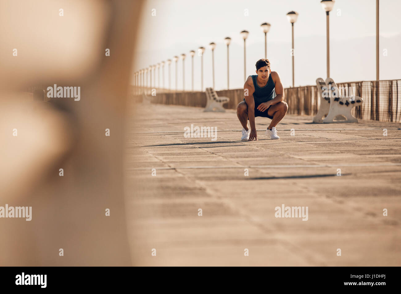 Shot of healthy young man taking a break after morning run. Male runner ...
