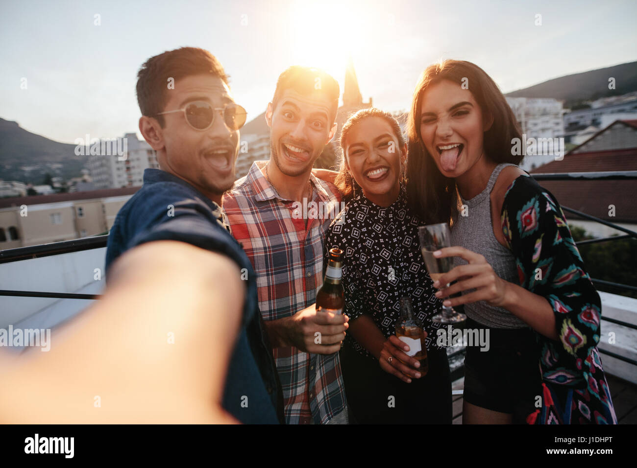 Group of people having a party on the rooftop making a selfie. Happy ...