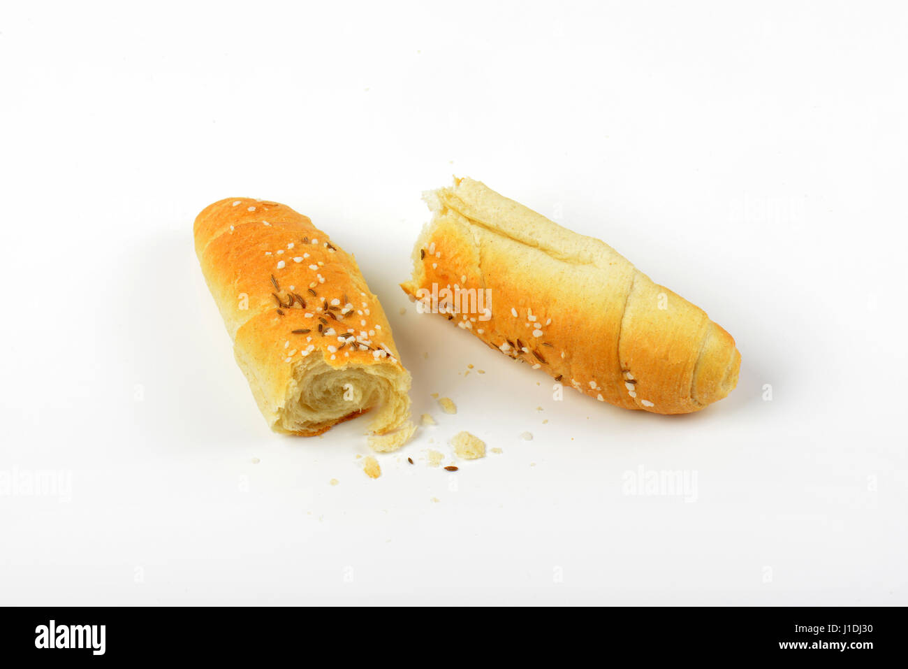 broken roll with salt and caraway seeds on white background Stock Photo ...