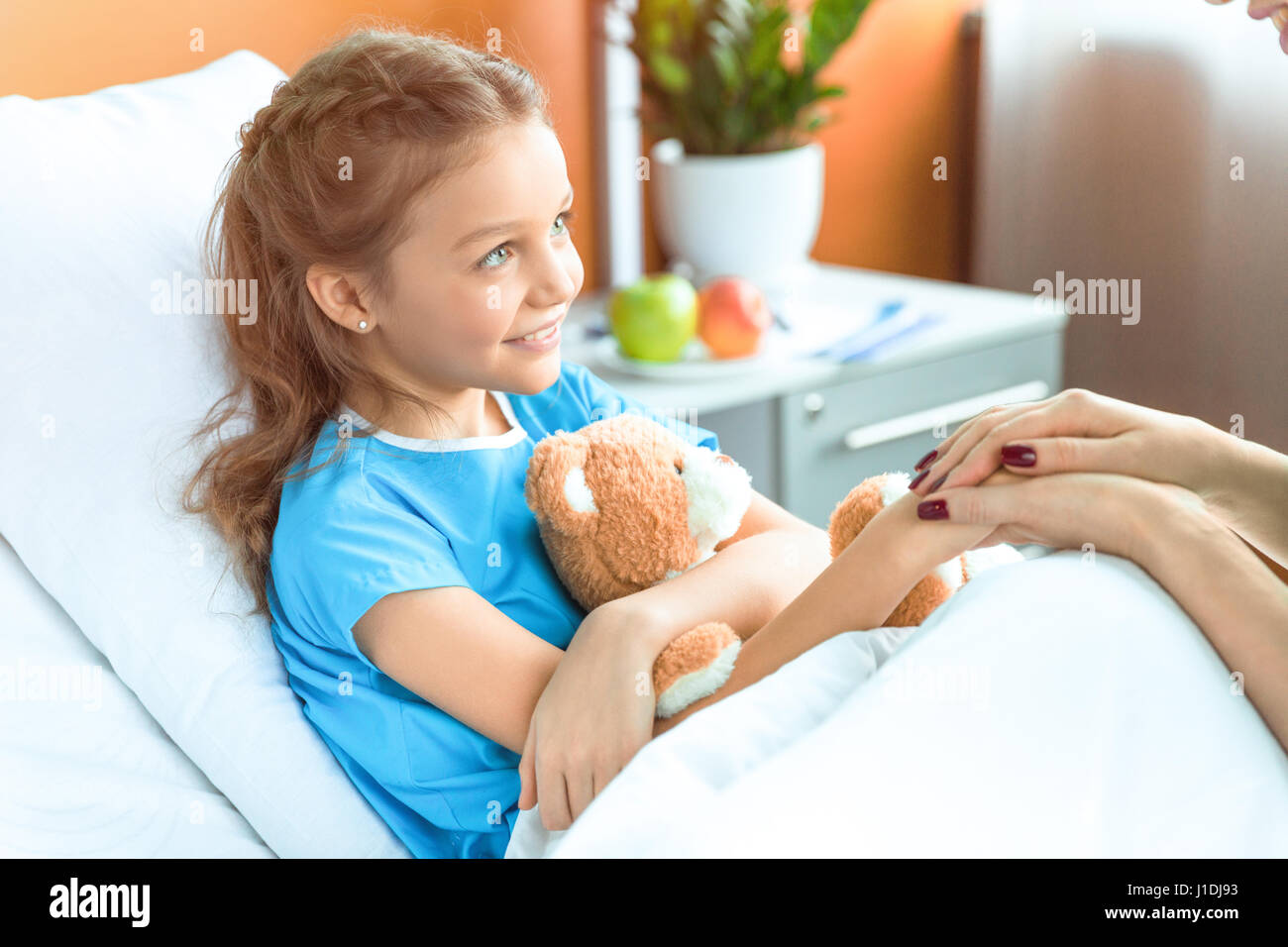 Doctor and little patient with teddy bear holding hands in hospital ...