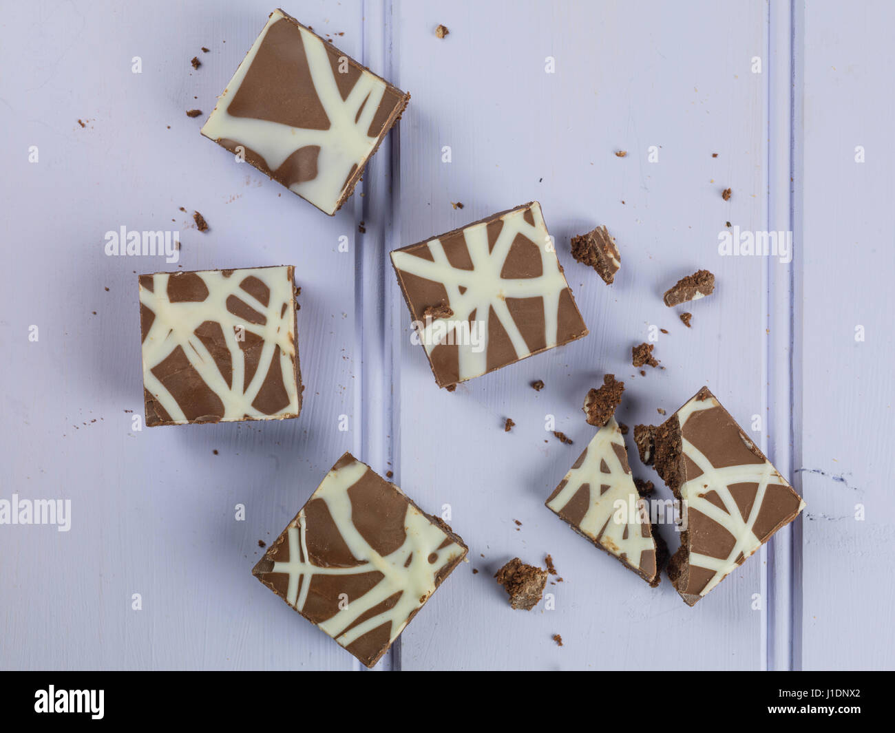 Individual Decorated and Iced Chocolate Tiffin Cakes Against a Lilac or ...