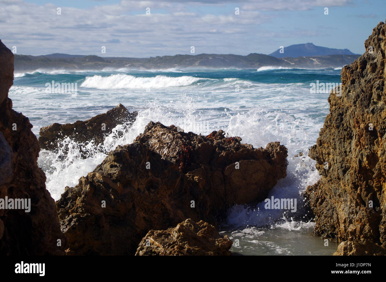 Waves crashing over rocks at a beach Stock Photo - Alamy