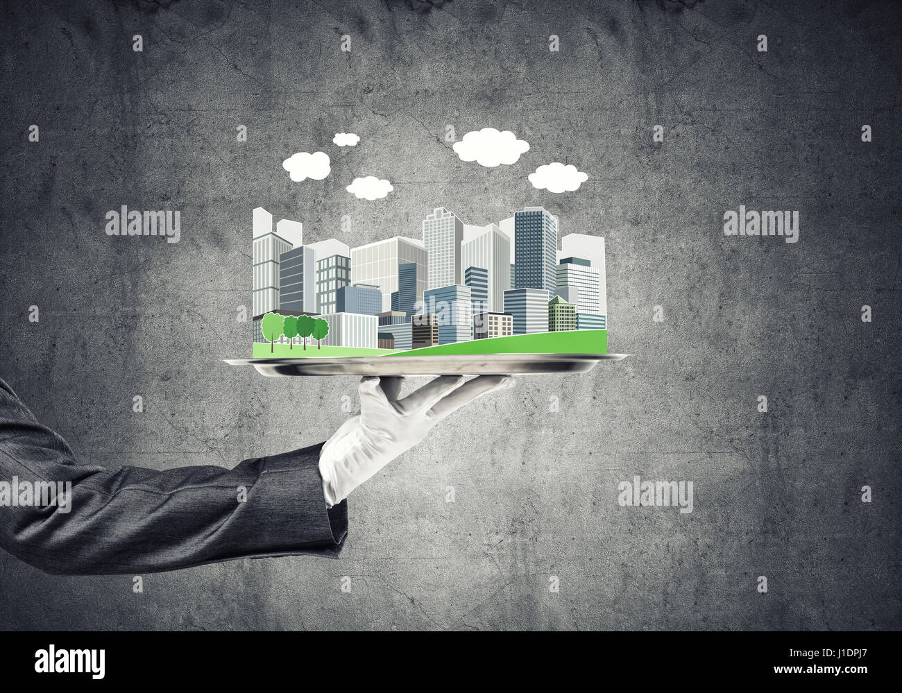 Hand holding metal tray with modern city model against concrete ...