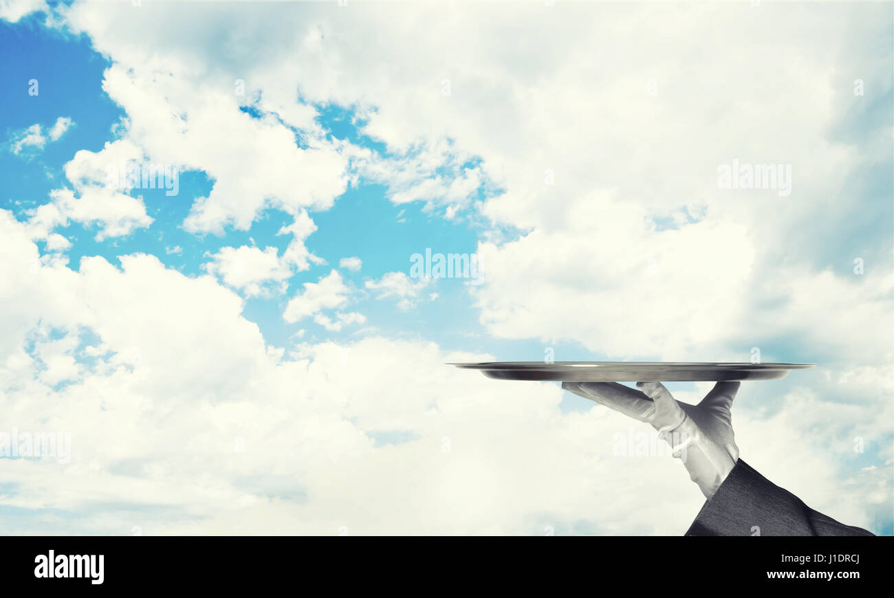 Waiter holding empty silver platter ready for product or item placement ...