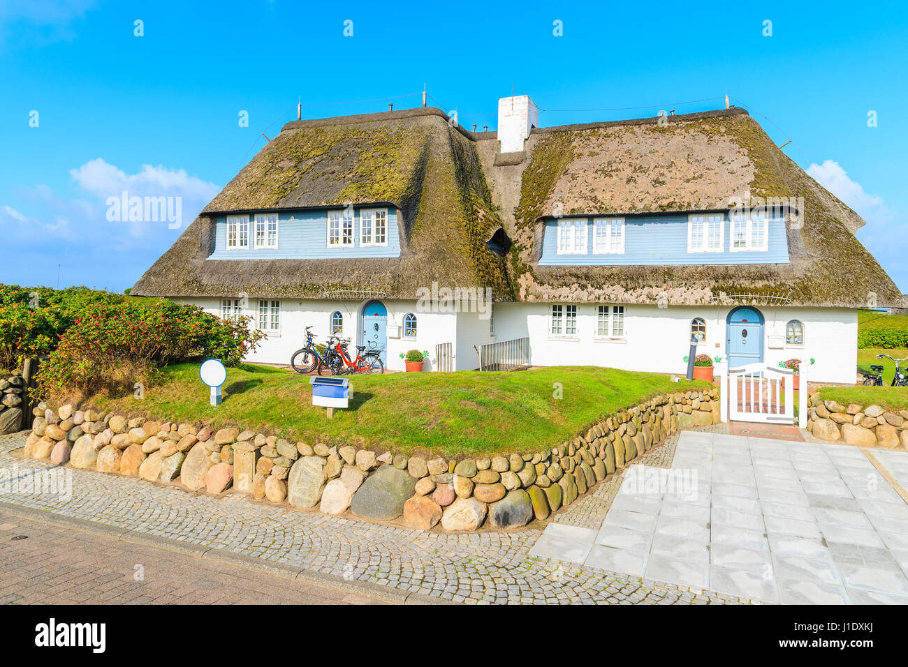 Traditional house with thatched roof and green garden on Sylt island in ...