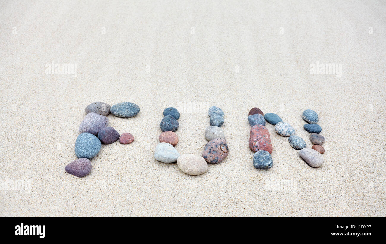 Fun word made of pebbles on a sandy beach Stock Photo - Alamy