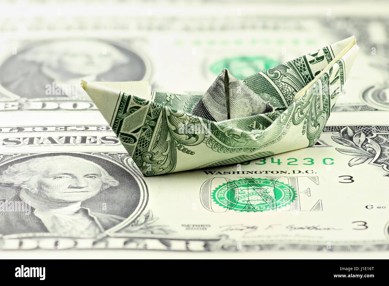 US Dollar paper boat on uncut sheet Stock Photo - Alamy