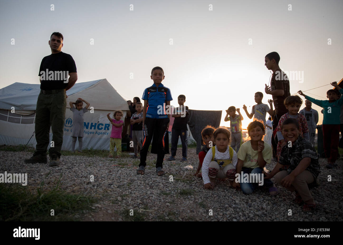 Bashiqa, Iraq. 20th Apr, 2017. Refugees stand and sit in front of tents ...